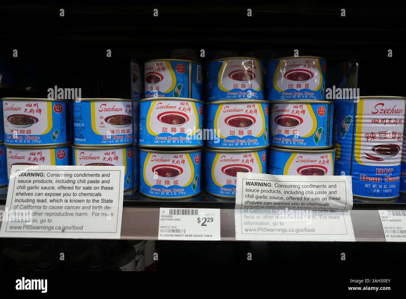 Cans of Szechuan sweet ban sauce sit with a California Proposition P65 ...