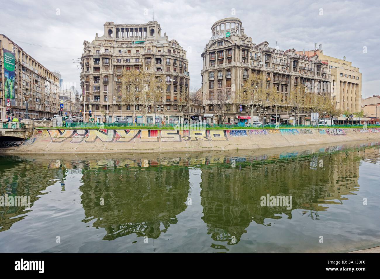 Old flat buildings reflectingin the Dâmbovița river in Bucharest ...