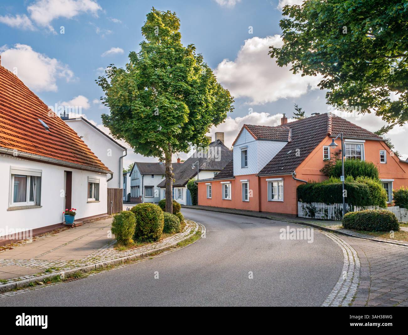 Street scene in Wiek with curved road and traditional plastered houses ...