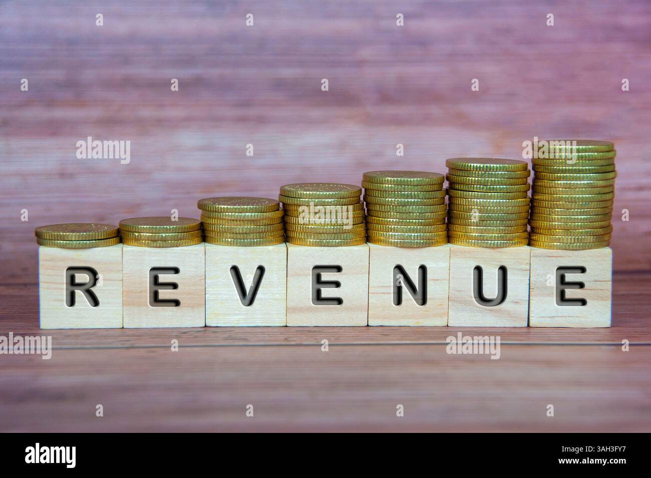 Revenue text on wooden cubes with stacking golden coins. Business ...