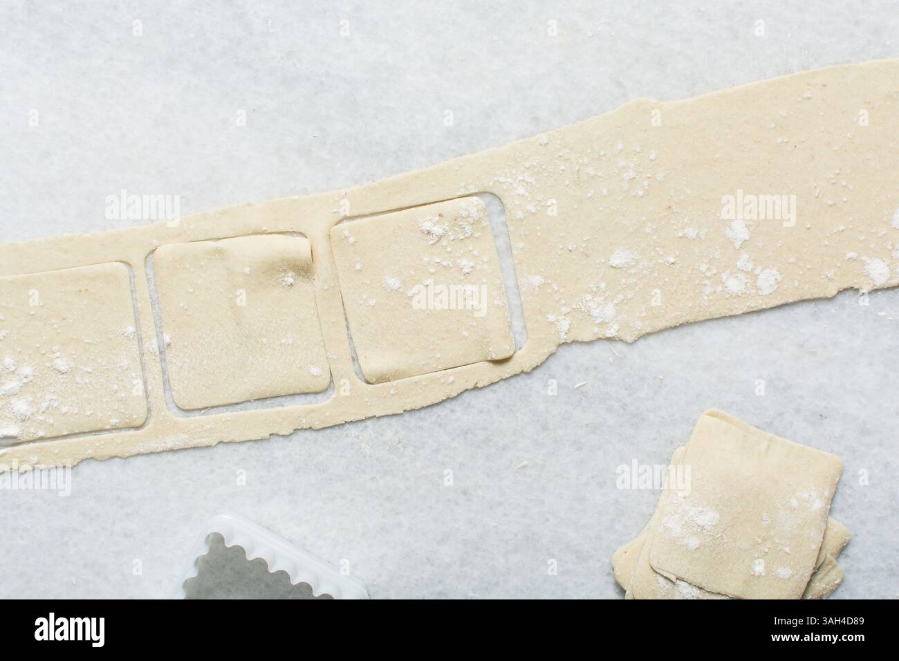 Overhead view of dumpling wrappers dough being cut, process of making ...