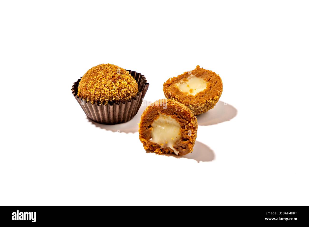 Honey ball in brown wrapper and next to it cut in half with milk ...