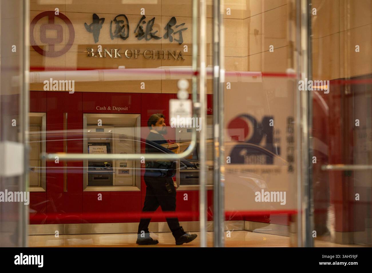 A security guard walks around the ATM machines at Bank of China U.S.A ...
