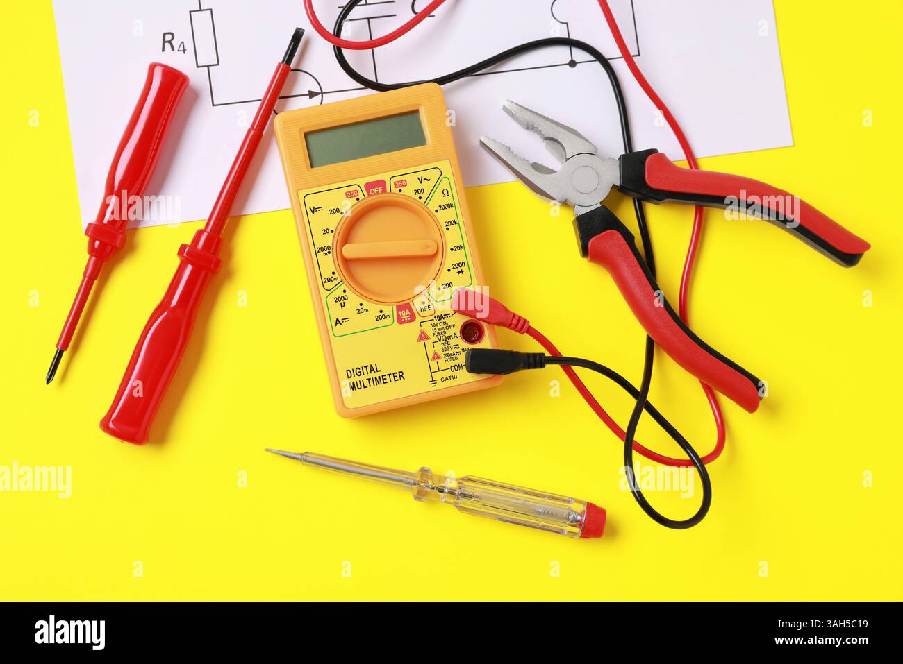 Different electrical tools and circuit diagram on yellow background ...