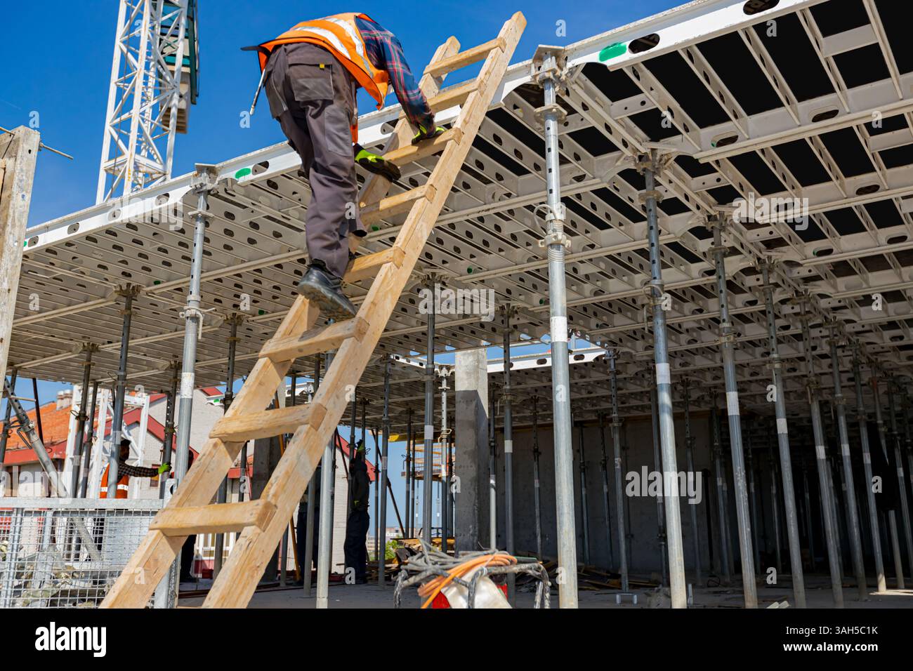 View from behind on construction worker with safety vest and helmet as ...