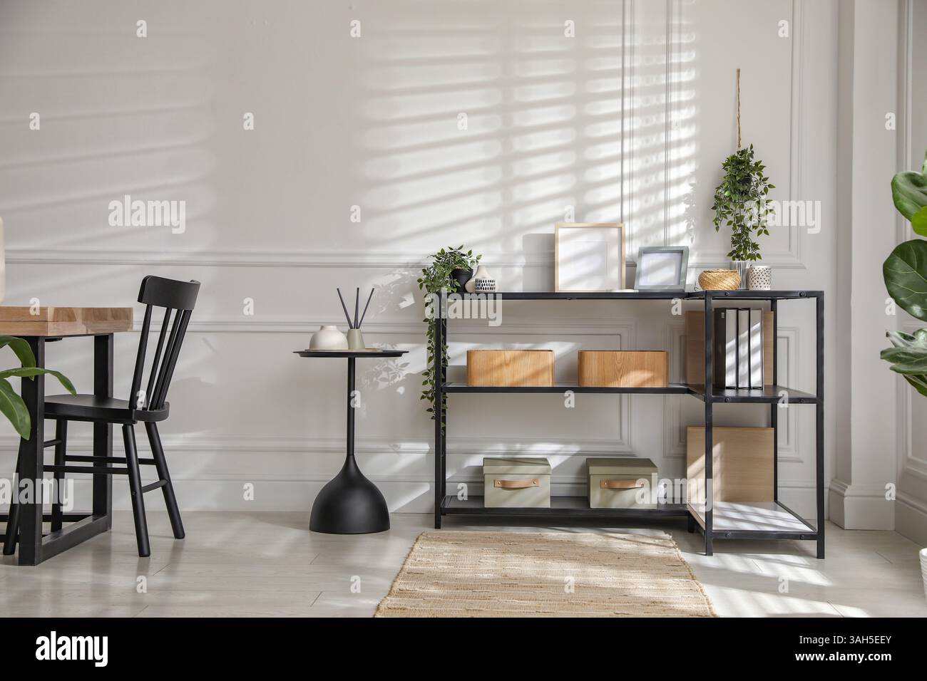 Console table with different decor and chair near white wall indoors ...