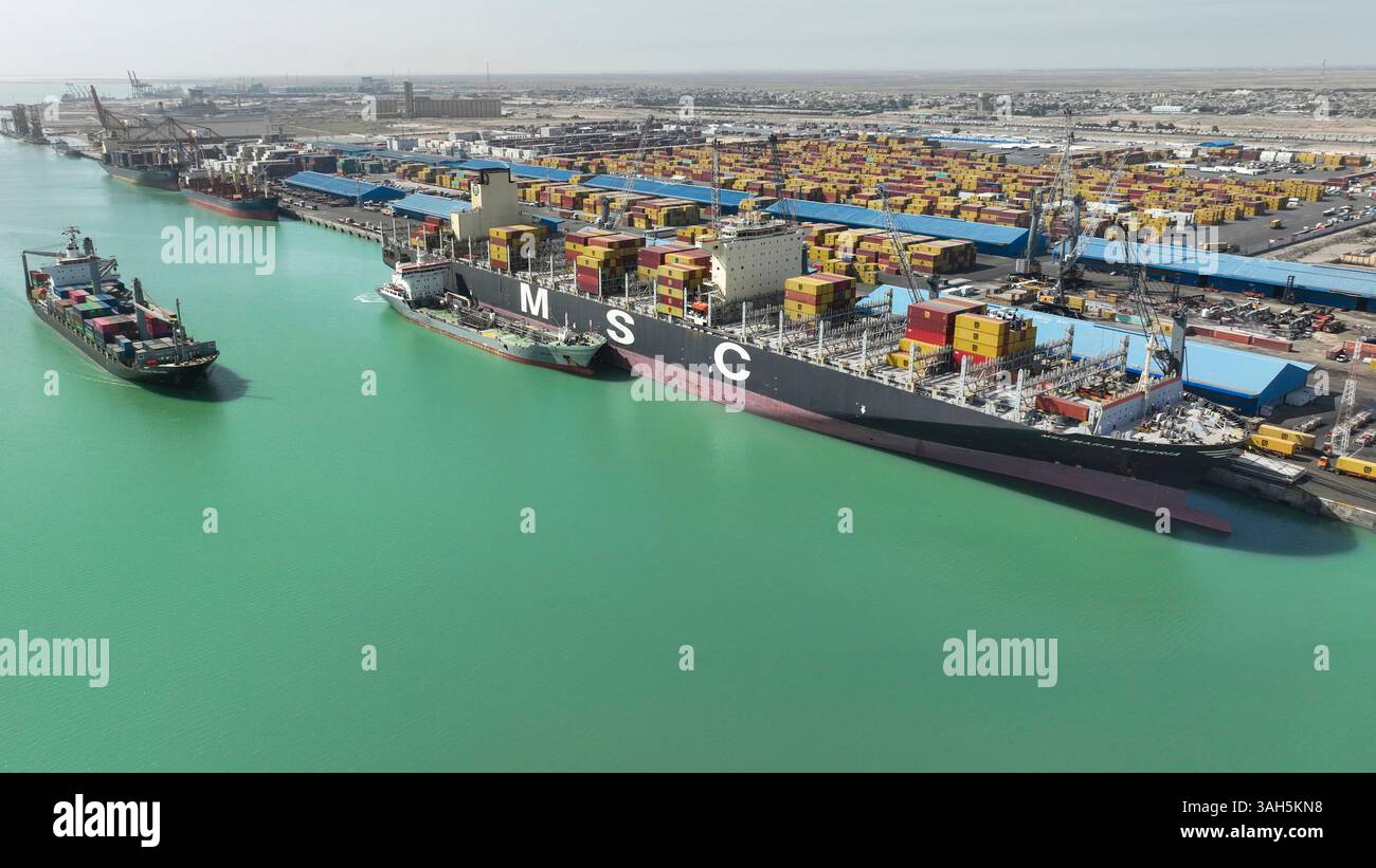 This aerial photo shows containers and moored boats at the port of Umm ...