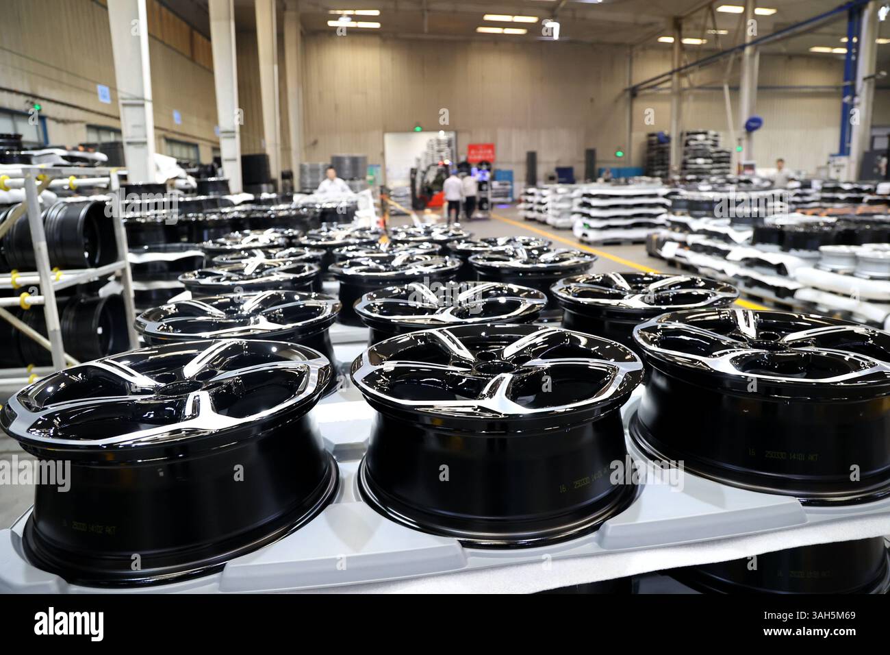 A worker produces wheel hub products at an automobile wheel hub ...