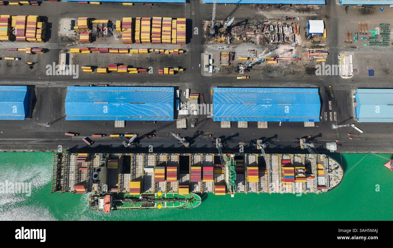 This aerial photo shows containers and moored boats at the port of Umm ...