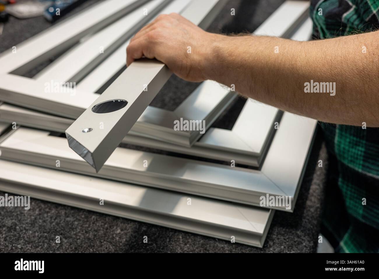 Aluminum profiles. Assembling aluminum frames in the factory Stock ...