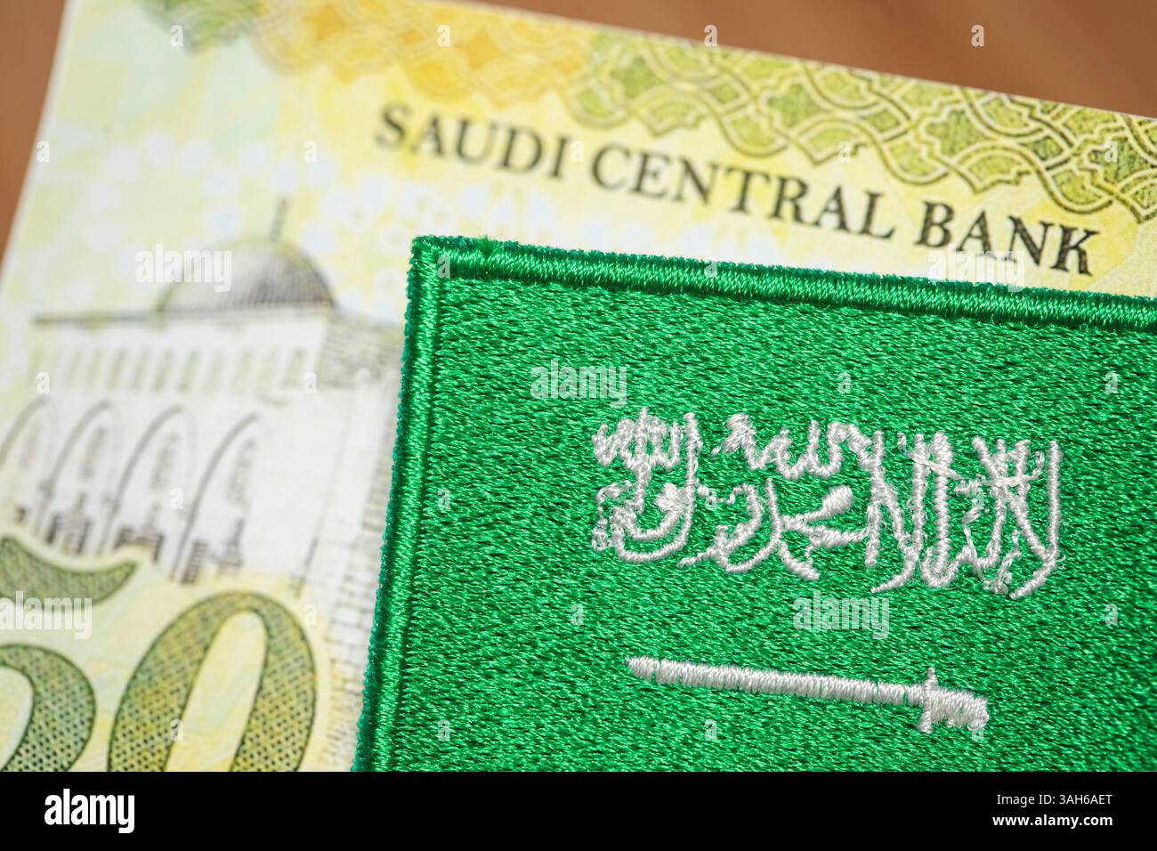 Embroidered Saudi Arabia flag and banknote with the words Saudi Central ...