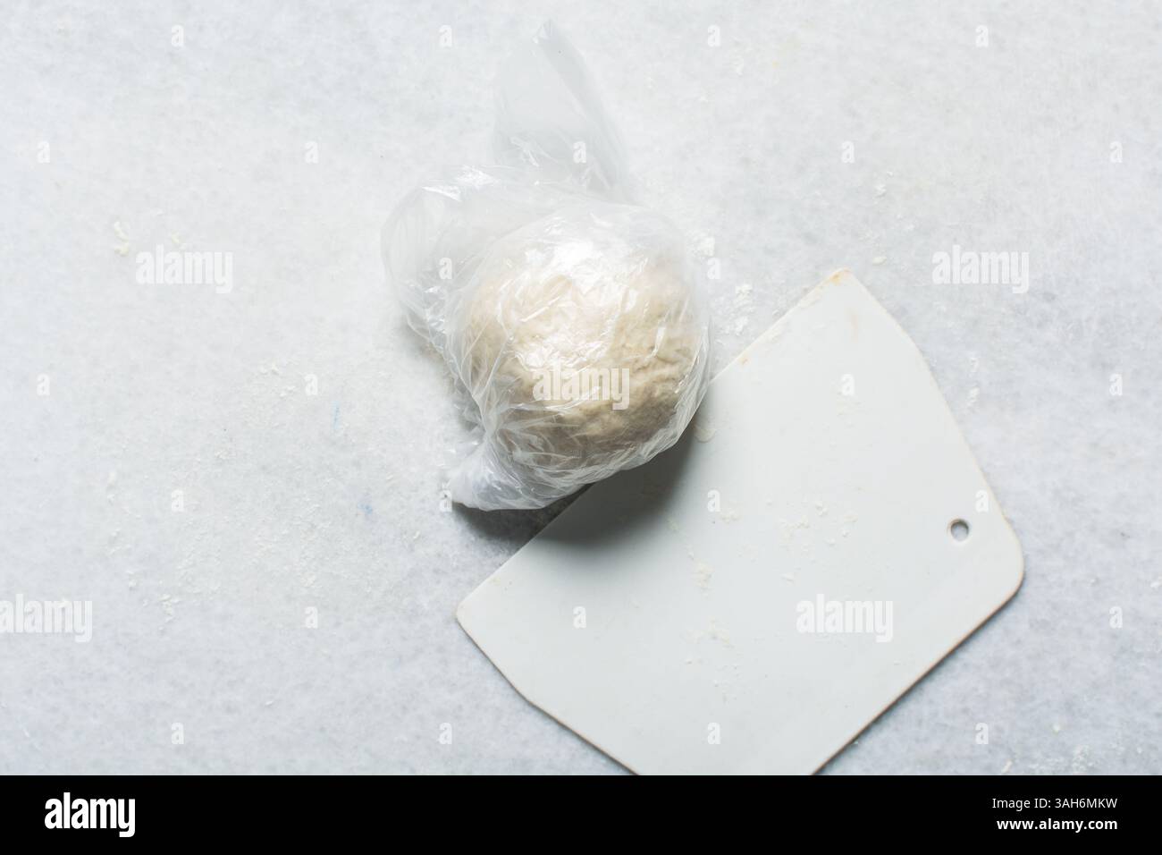 Overhead view of dumpling wrappers dough on a granite countertop ...