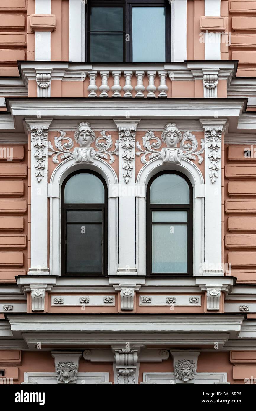 Two arched windows with white bas-relief against a pink colored wall ...