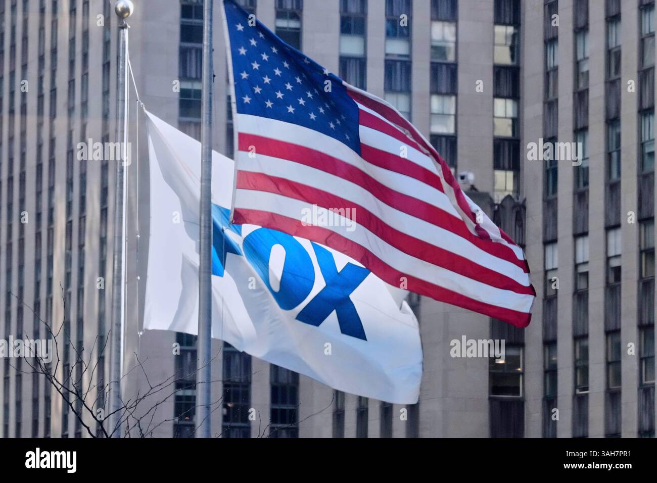 An American flag and a Fox flag fly outside Fox headquarters, in New ...
