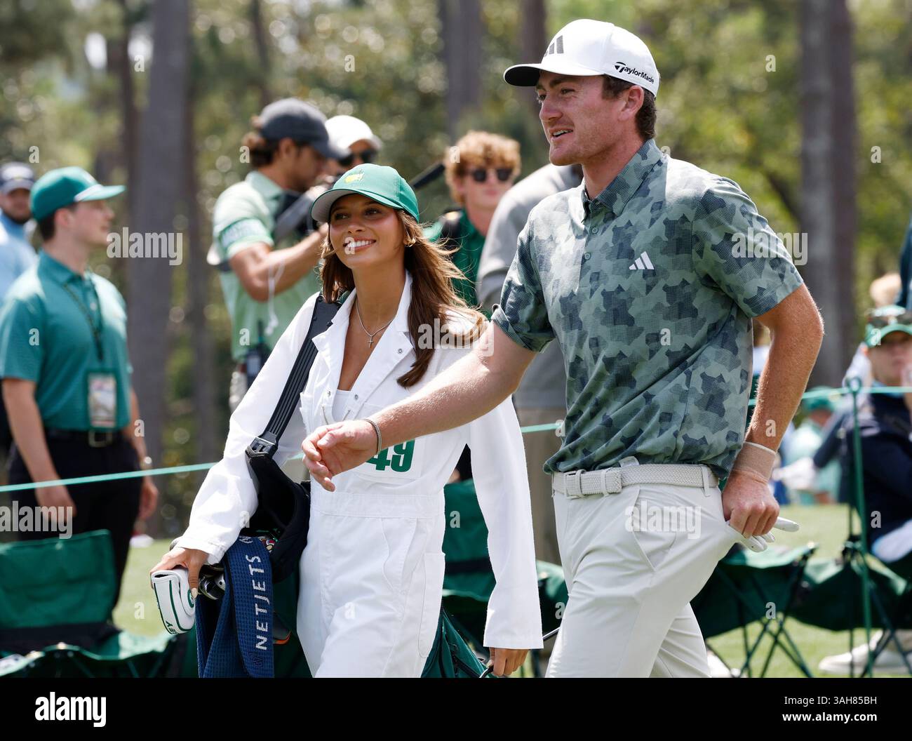 Nick Dunlap walks on the course with friend and caddie Erika Baker ...