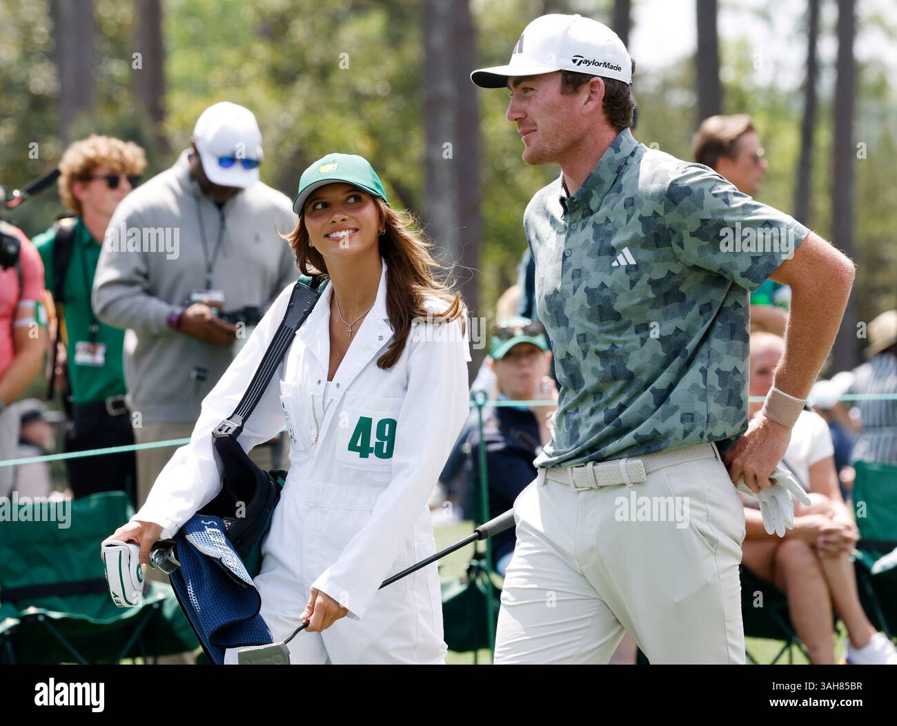 Nick Dunlap walks on the course with friend and caddie Erika Baker ...