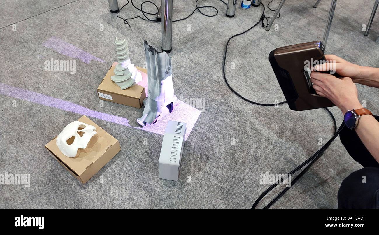 3D scanning. Working portable 3D scanner. Man scanning an object with a ...