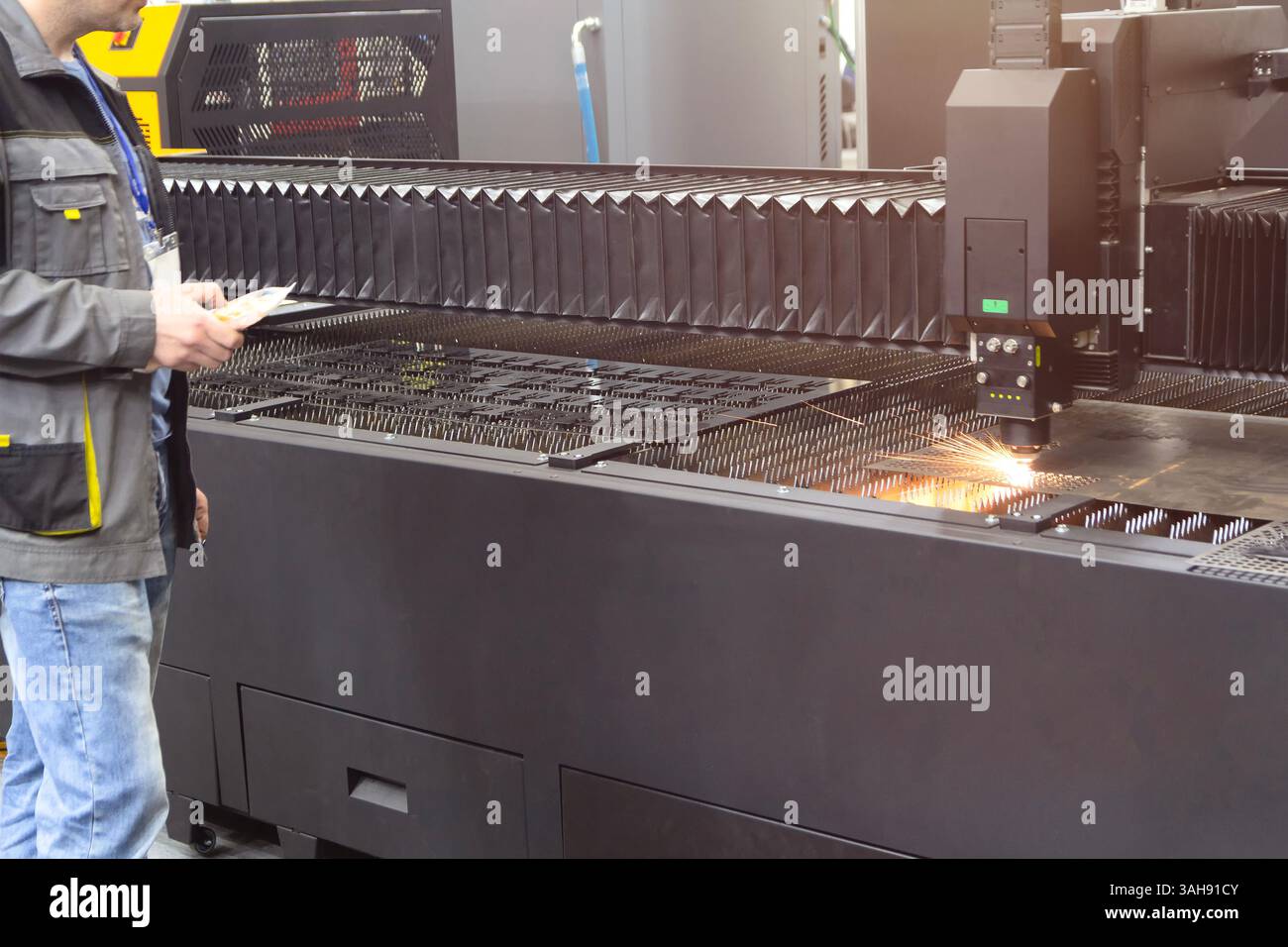 Worker operates automated metalworking machine hi-res stock photography ...