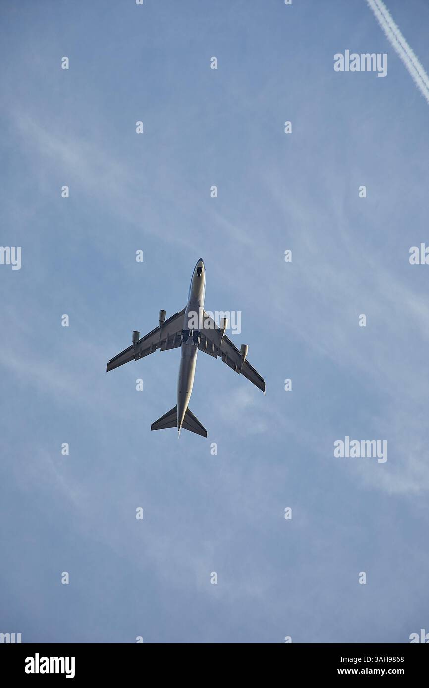Large jet airplane flying overhead, blue sky Stock Photo - Alamy