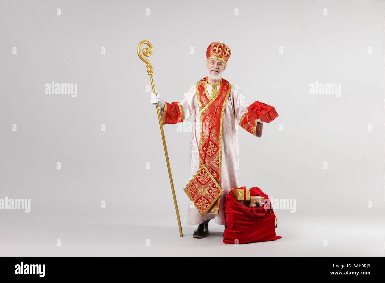 Saint Nicholas with sack full of gifts on light grey background Stock ...