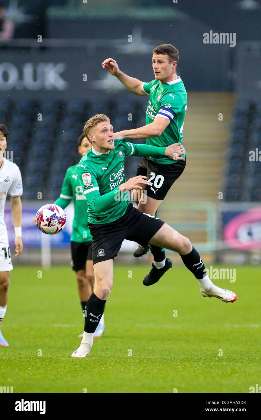 Adam Randell and Kornél Szűcs of Plymouth Argyle jump for the ball ...