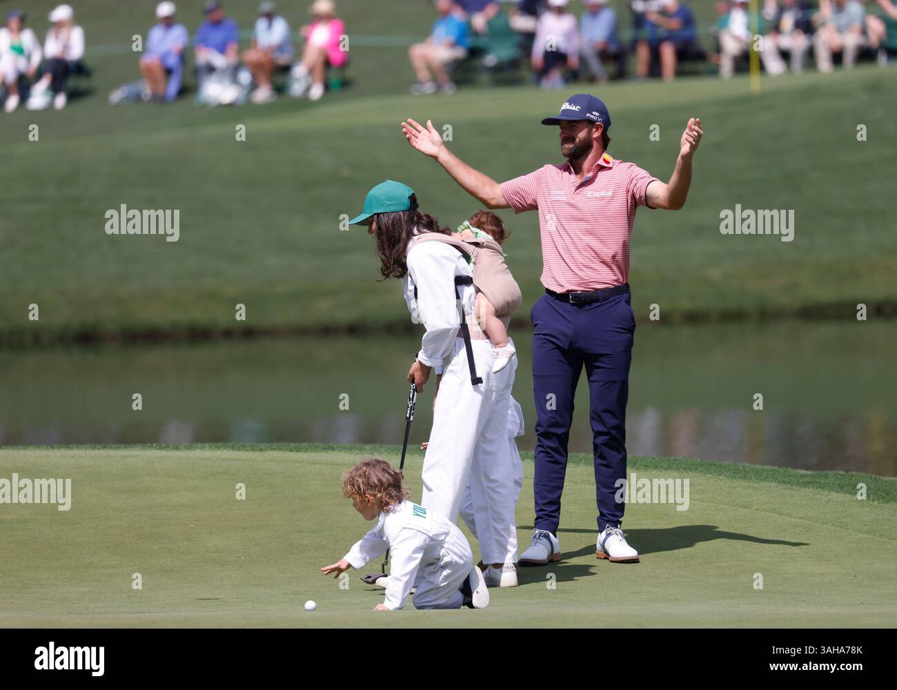 Cameron Young gestures as his wife Kelsey Dalition and son Henry take a putt during the 2025 ...