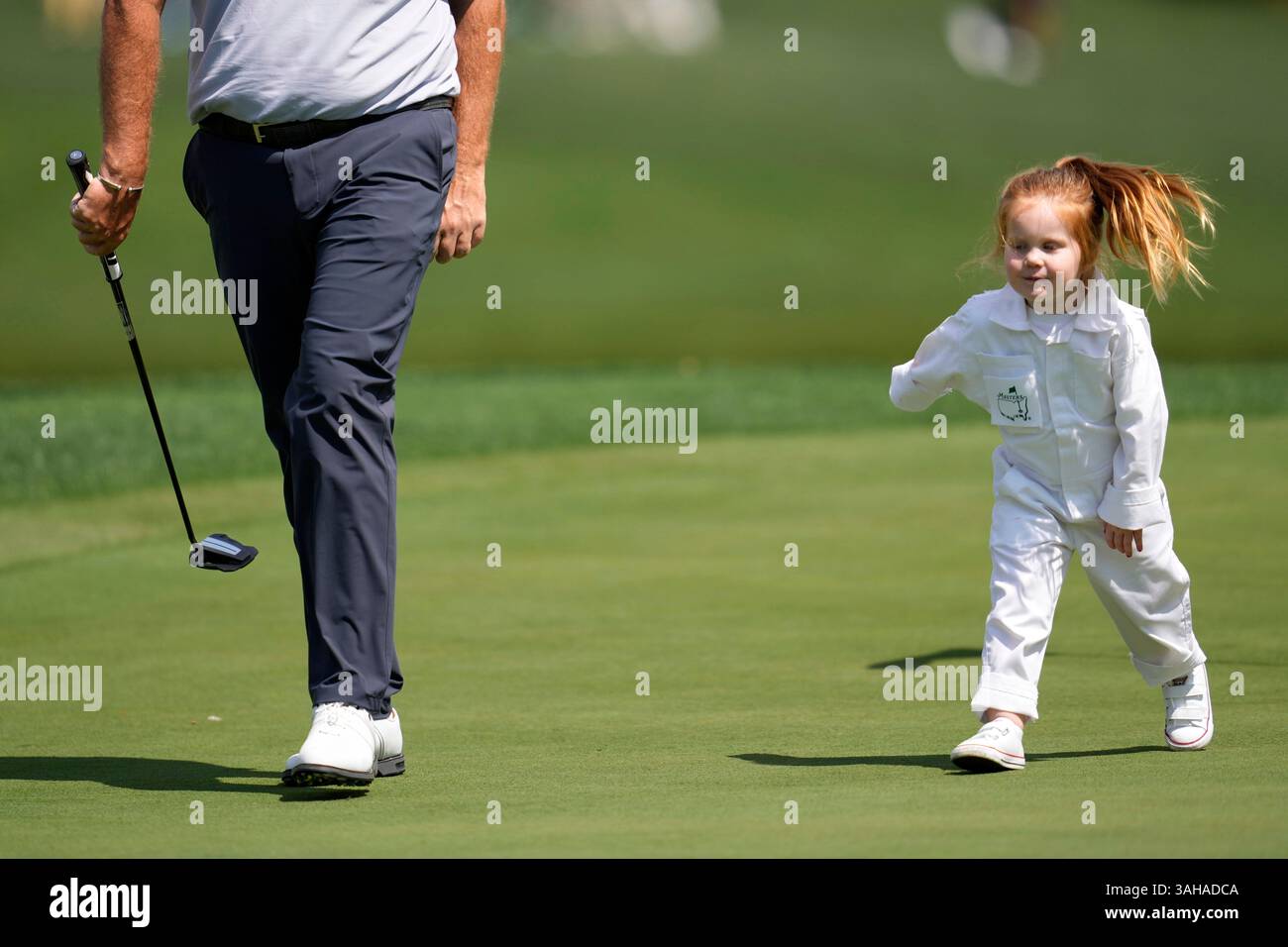 Shane Lowry, of Ireland, walks on the first hole with daugher Ivy, 3 ...