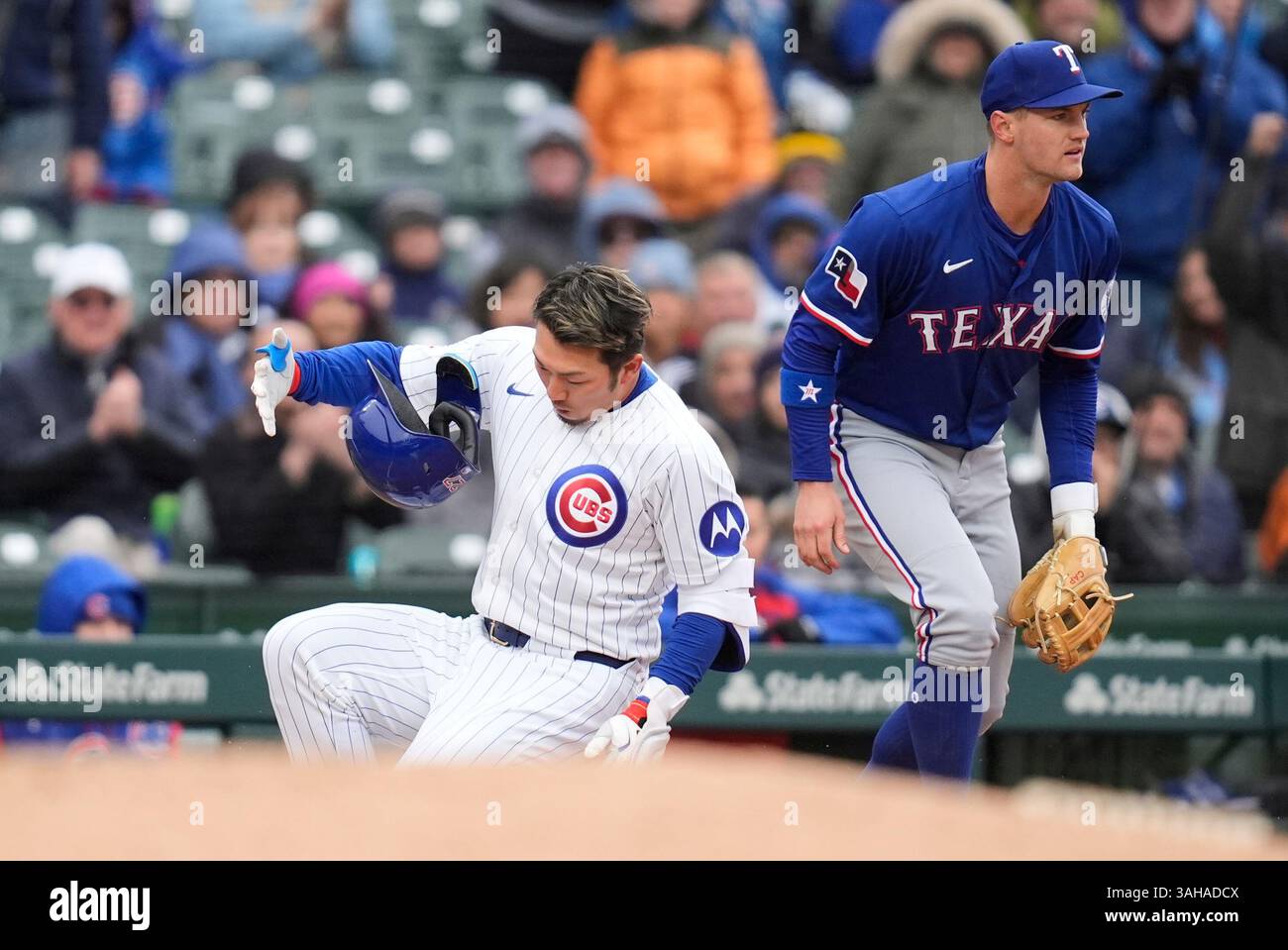 Chicago Cubs designated hitter Seiya Suzuki, left, slides past Texas ...