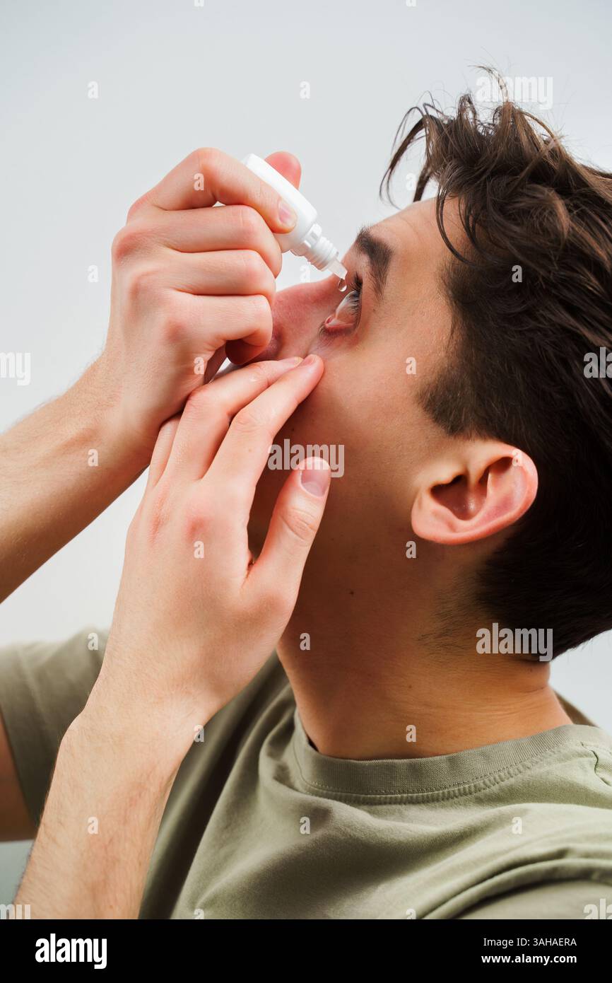 Man drips eye with eyes drops due to irritation problem. Applying eye ...