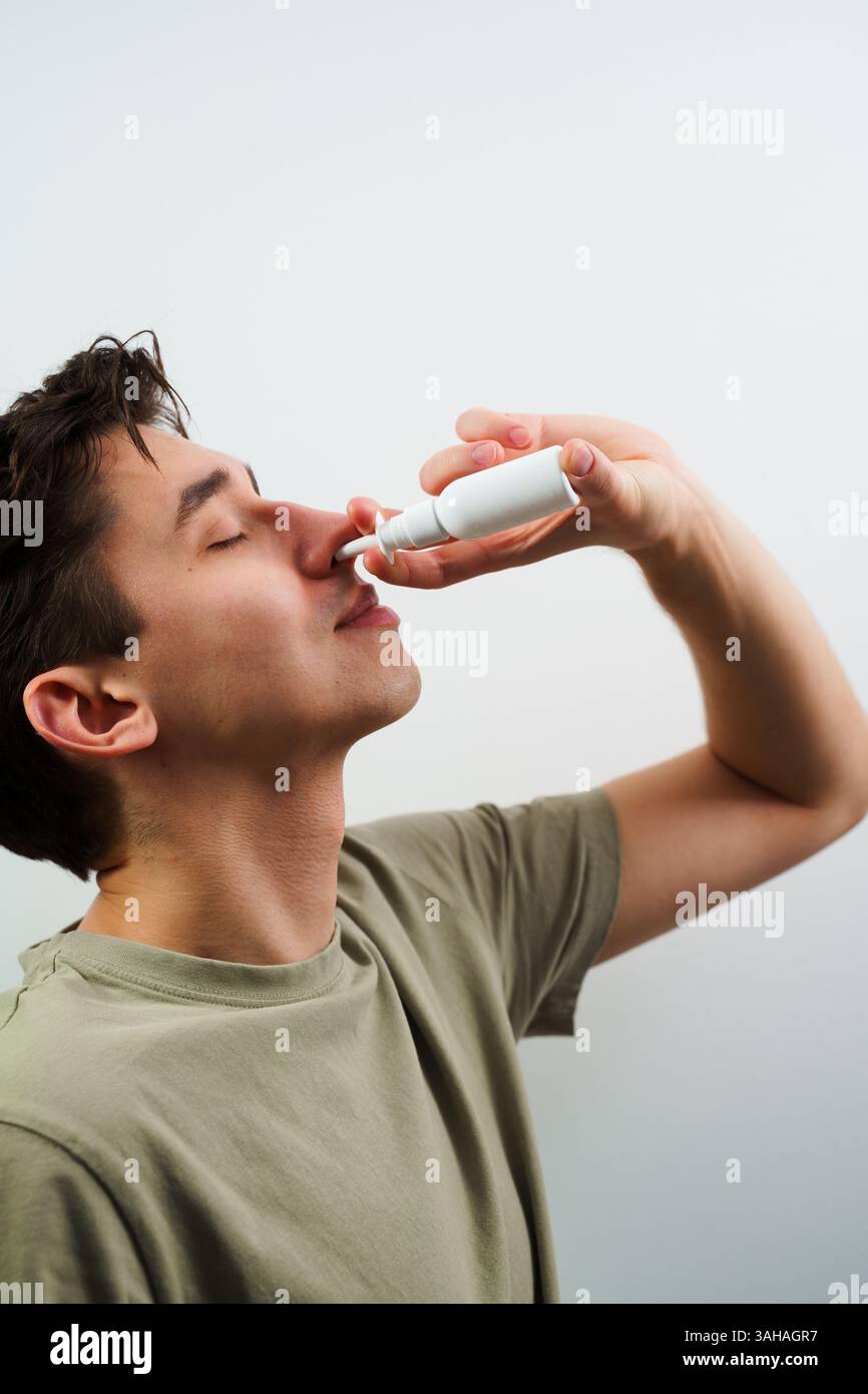 Man uses nasal spray to help a flu. Patient is taking nose drops for ...