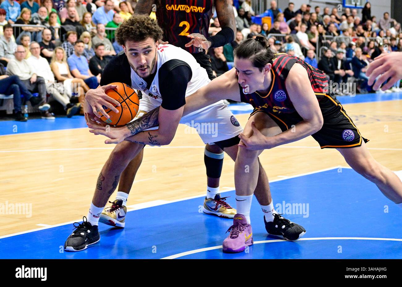 Ryland Holt of Nymburk, left, and Samet Geyik of Galatasaray in action ...