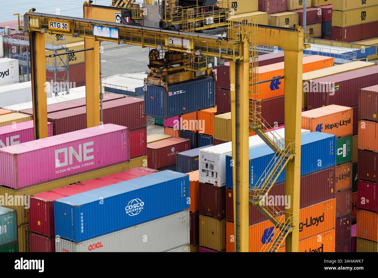 Cranes unload containers from a cargo ship at the seaport in ...