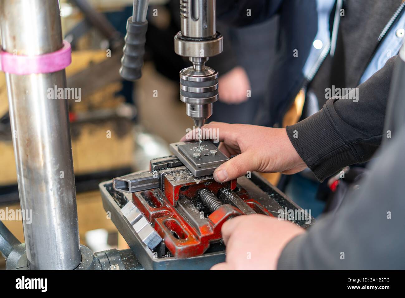 Worker operating a hand-operated industrial drill in a workshop Stock ...
