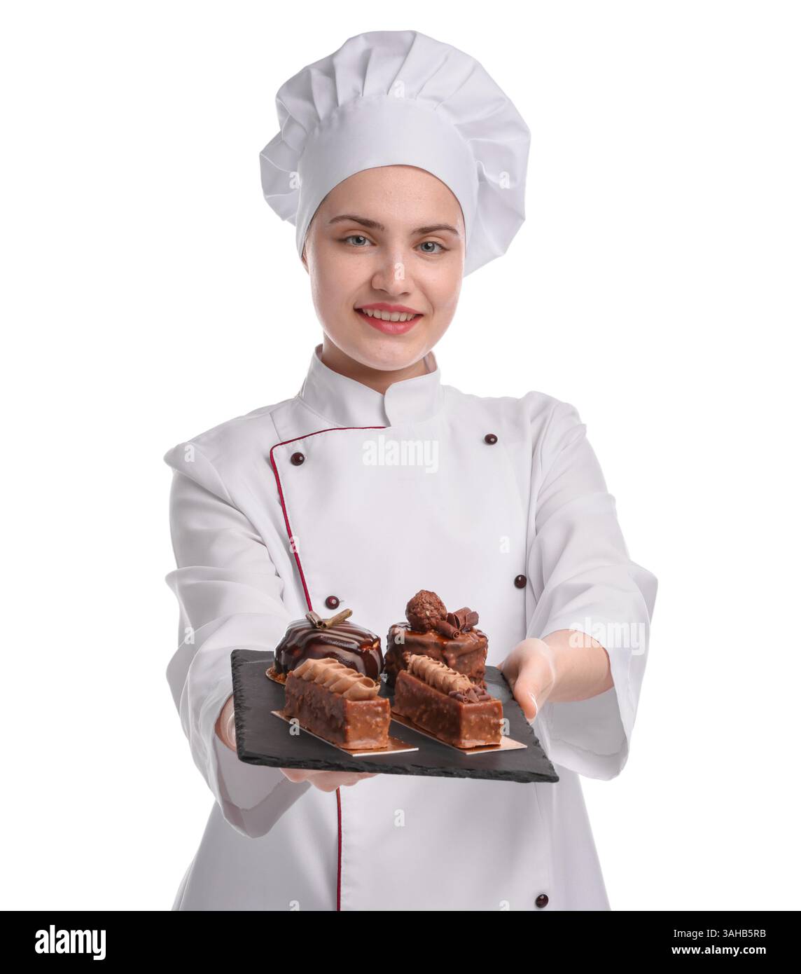 Happy confectioner in uniform holding delicious chocolate desserts on ...