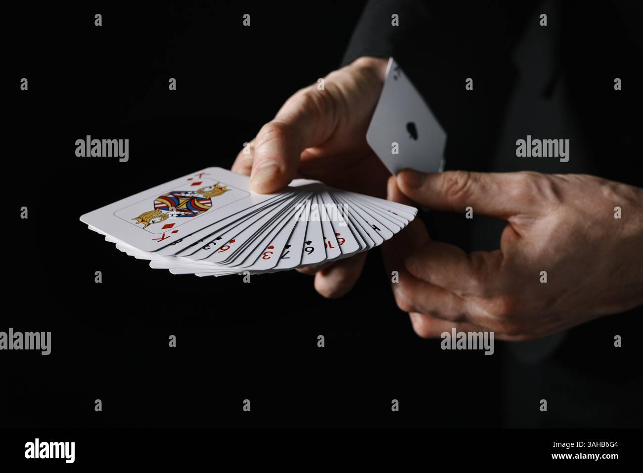 Illusionist hiding one playing card up his sleeve while showing deck on ...