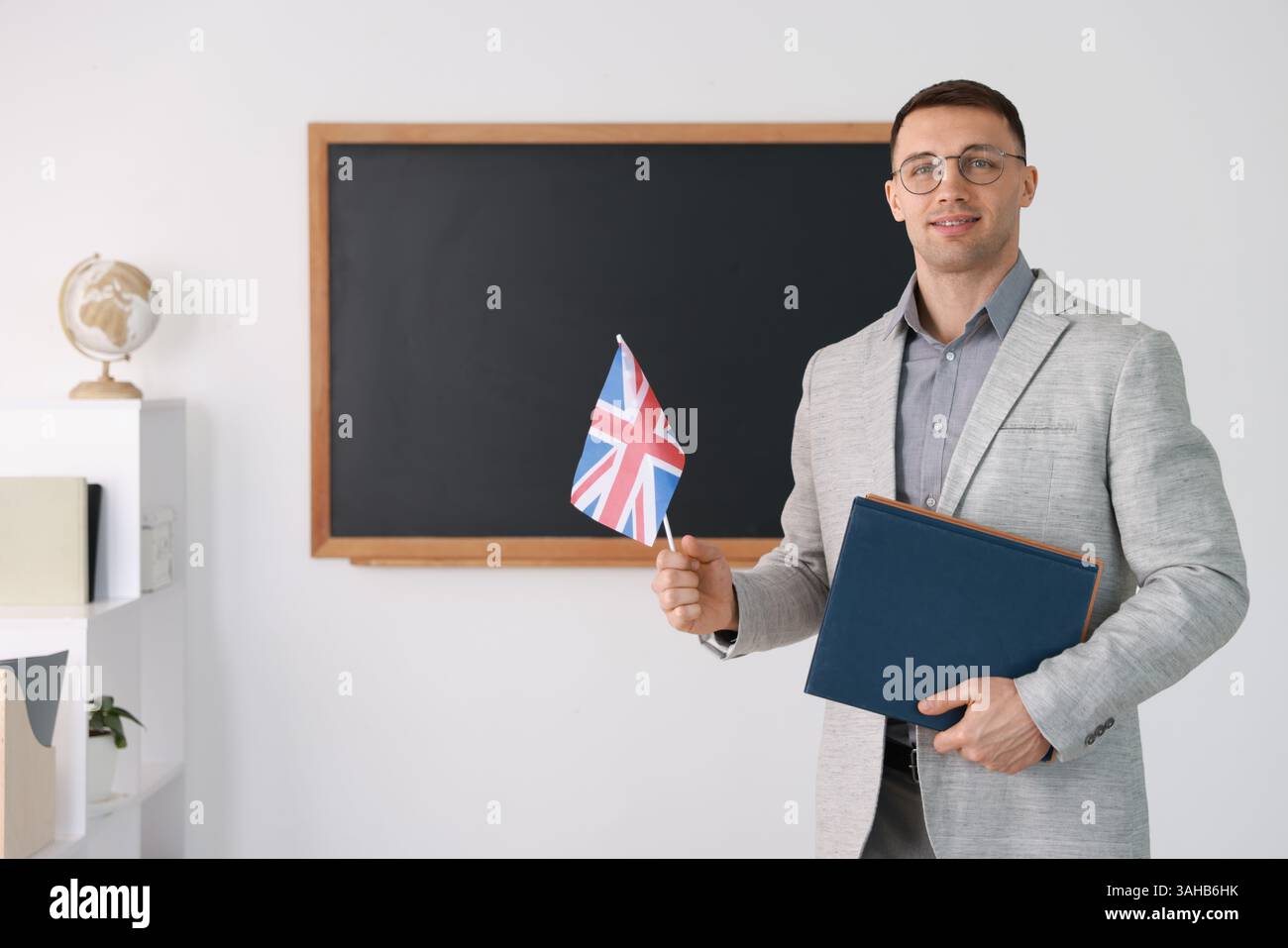English teacher with UK flag against blackboard in classroom Stock ...
