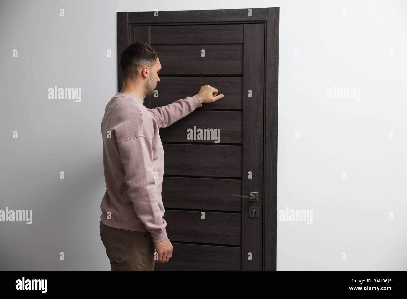 Man knocking on door to his friends apartment Stock Photo - Alamy
