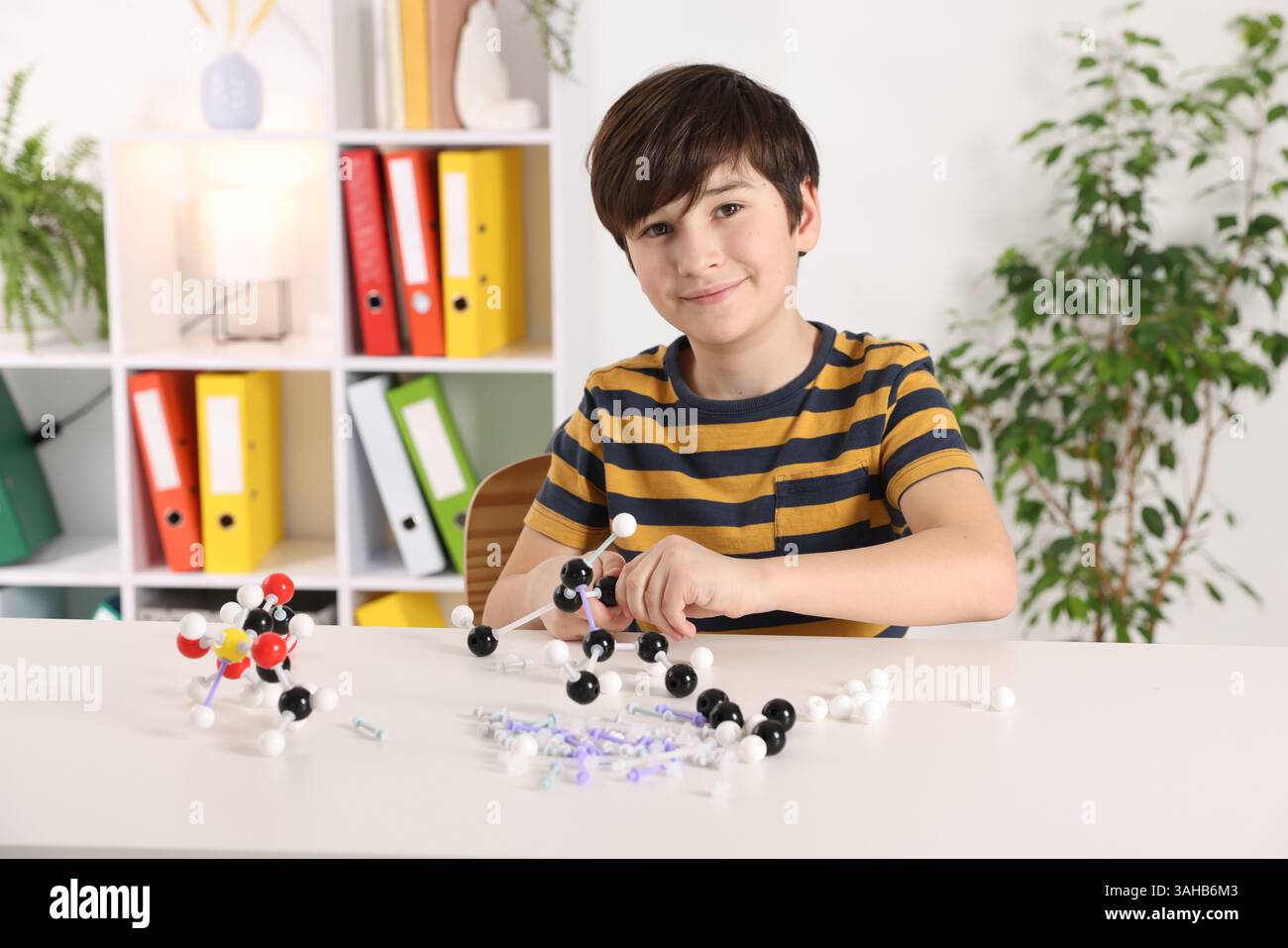 Boy making DNA structure model at desk indoors. Space for text Stock ...