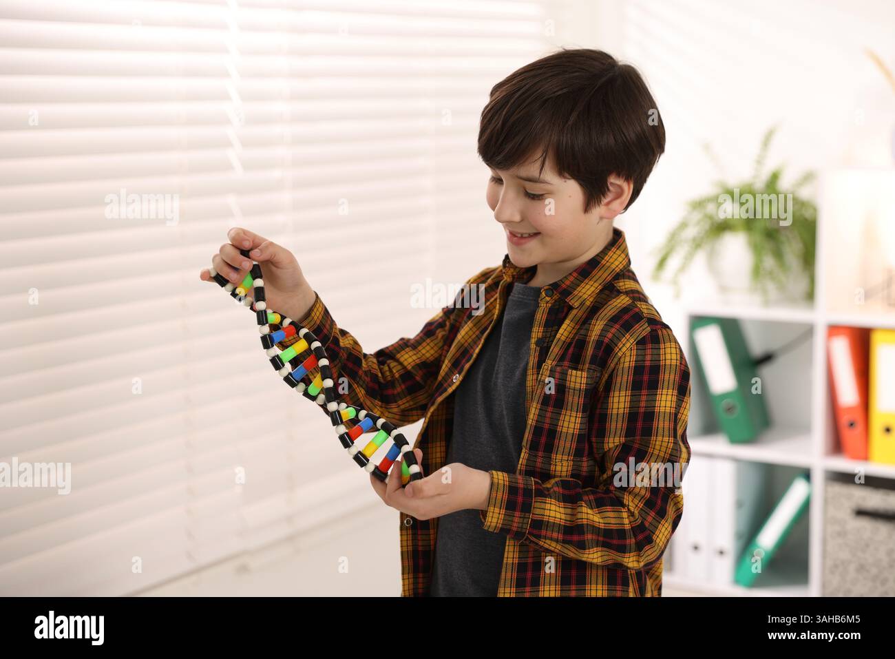 Smiling boy with DNA structure model indoors Stock Photo - Alamy