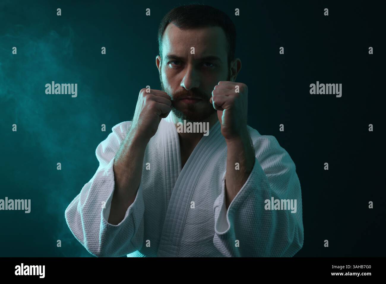 Karate fighter wearing uniform in color lights and smoke Stock Photo ...