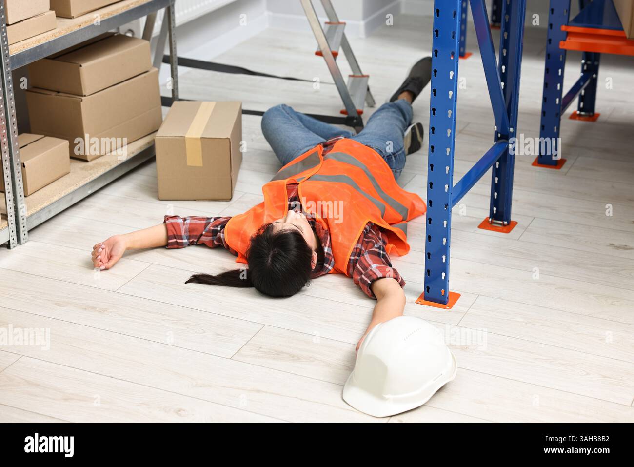 Accident at work. Unconscious woman lying on floor in warehouse Stock ...