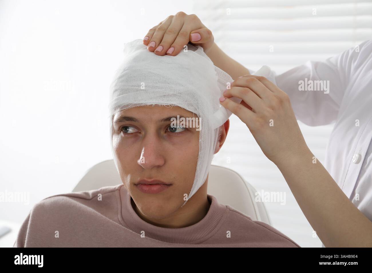 Doctor bandaging patient's head in clinic, closeup Stock Photo - Alamy