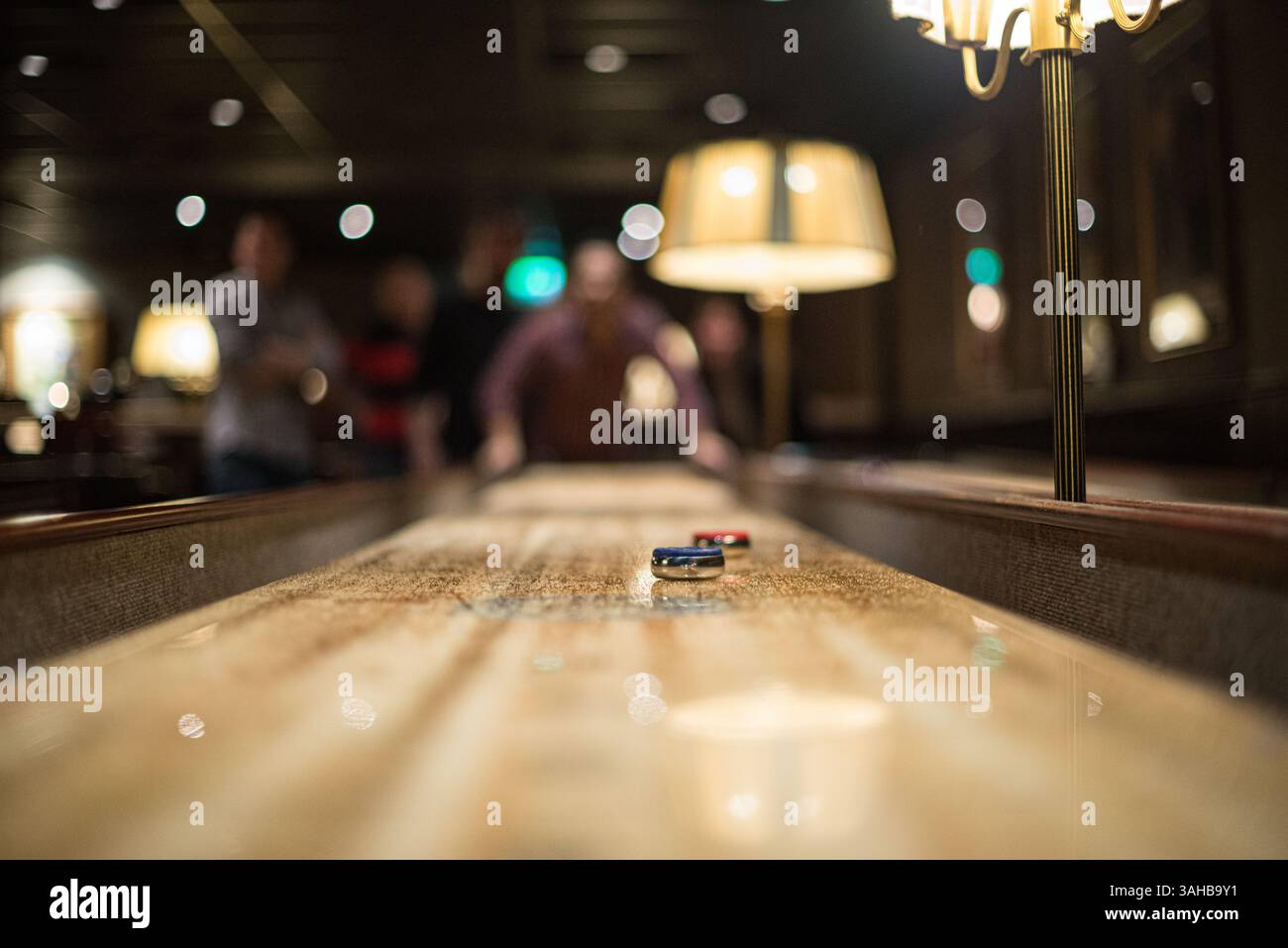 Shuffleboard game in dimly lit bar Stock Photo - Alamy