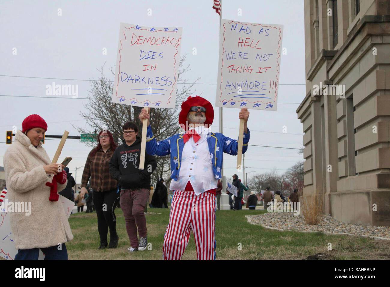A protester dressed as Uncle Sam holds signs at the La Porte County ...