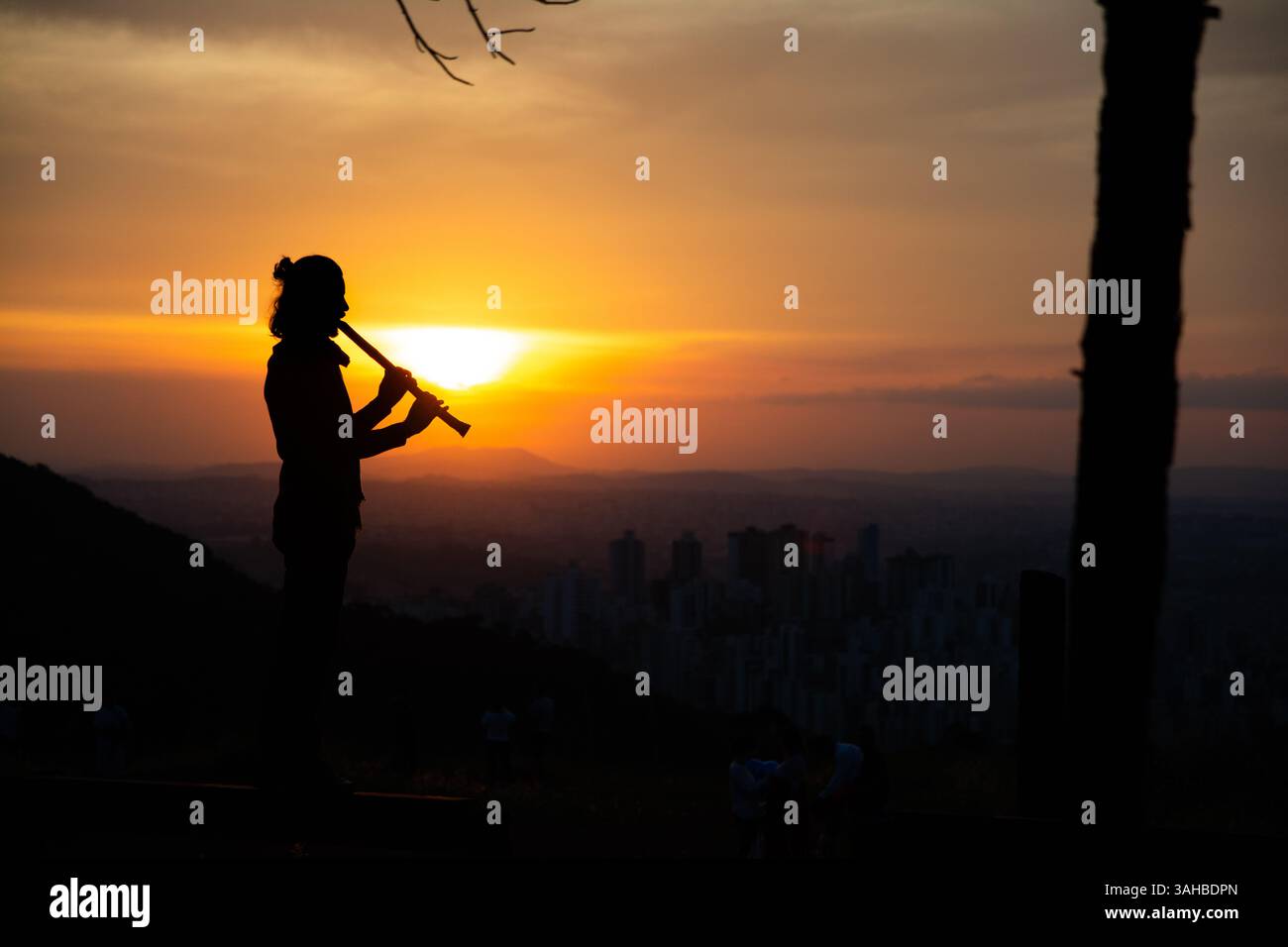 the silhouette of a male piper playing a flute against a setting sun on ...