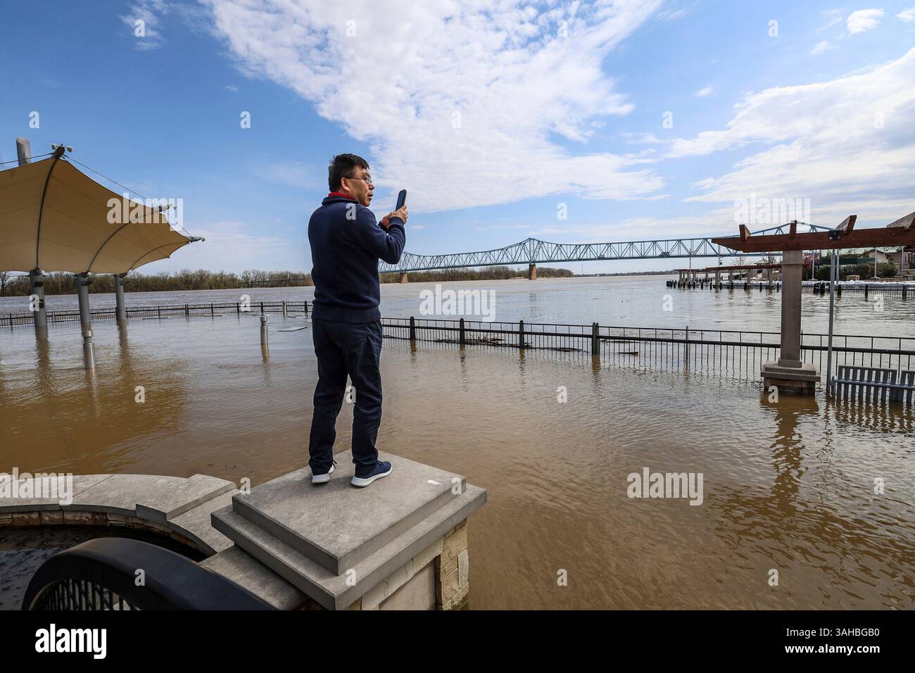 Ming Ji takes a picture while looking at flooding from the Ohio River at Smothers Park ...