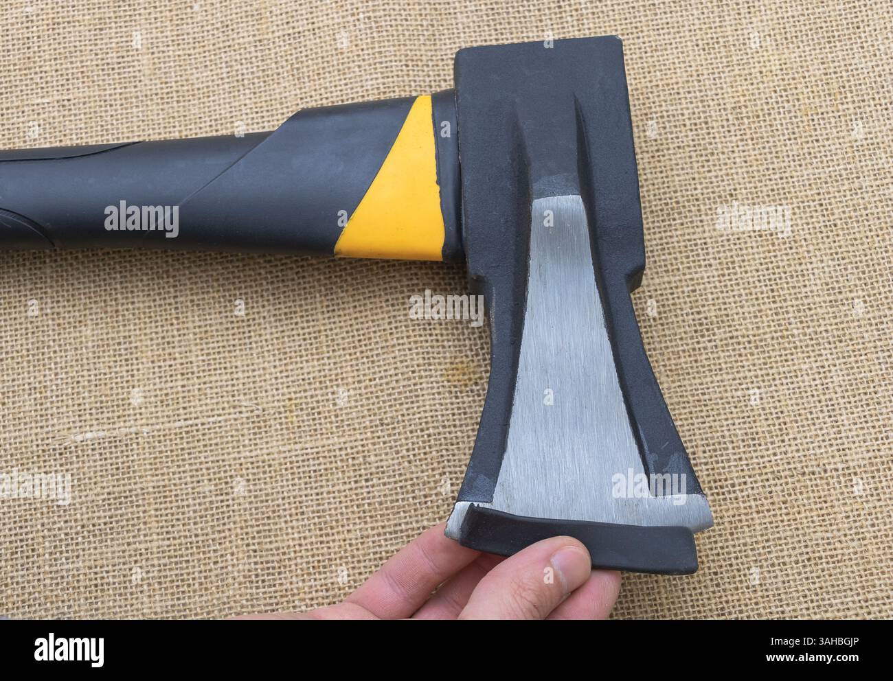 An axe with black and yellow matte-finish. The blade is sharp, the ...