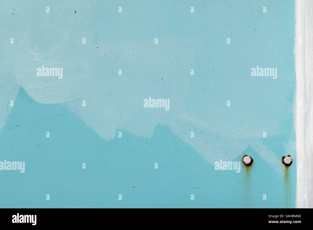 A textured close-up photo of a light blue metal wall with two rusty ...