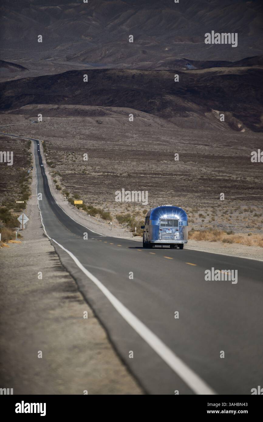 Silver Airstream camper travel trailer on an empty road in the area of ...