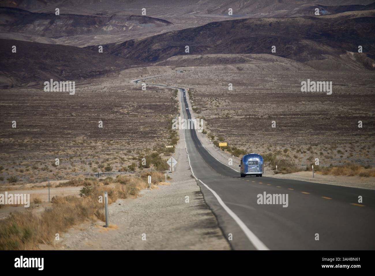 Silver Airstream camper travel trailer on an empty road in the area of ...